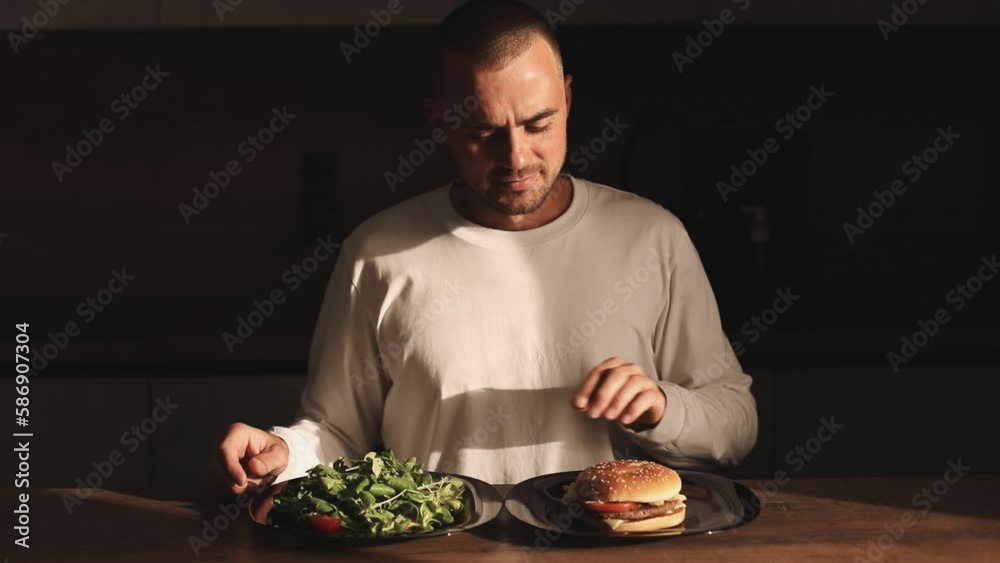 Frowning man make choice salad or burger, unhealthy or healthy food ...