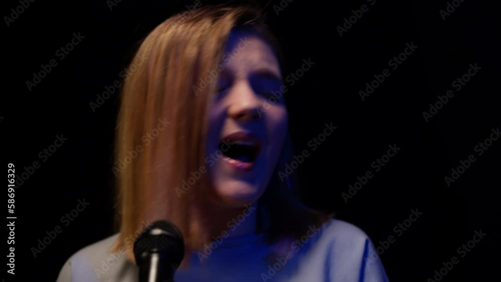 Talented confident teenage girl singing on stage as live camera ...