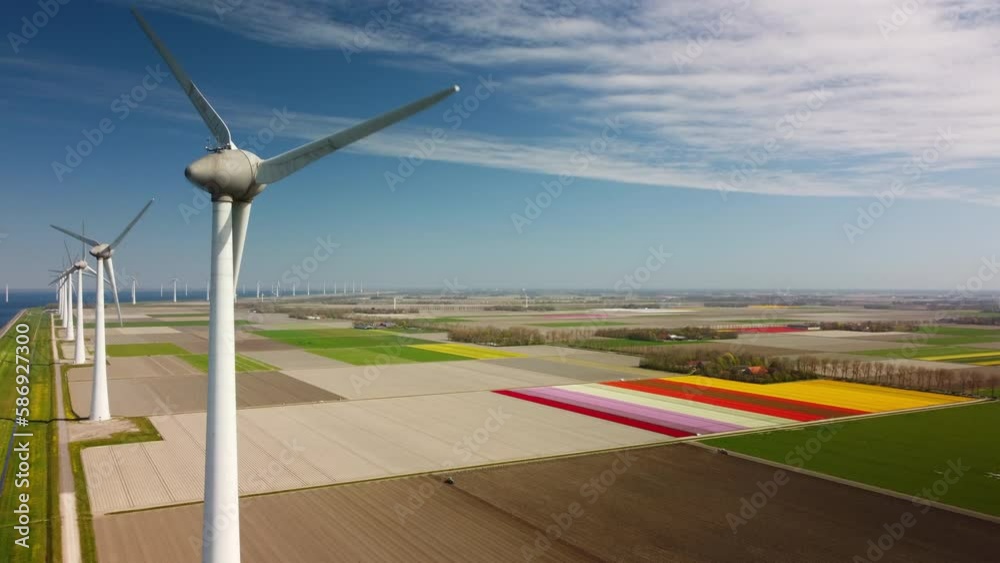 Wind turbines on a levee producing sustainable renewable energy in a ...