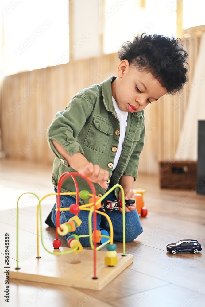 Concentrated little african american boy playing toys sitting on warm ...