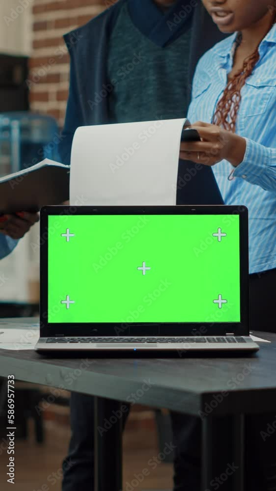 Vertical video: Employees team analyzing papers using greensceen on ...
