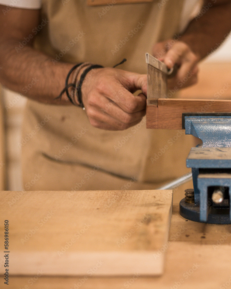 Close up of a young man working as carpenter in small carpentry ...