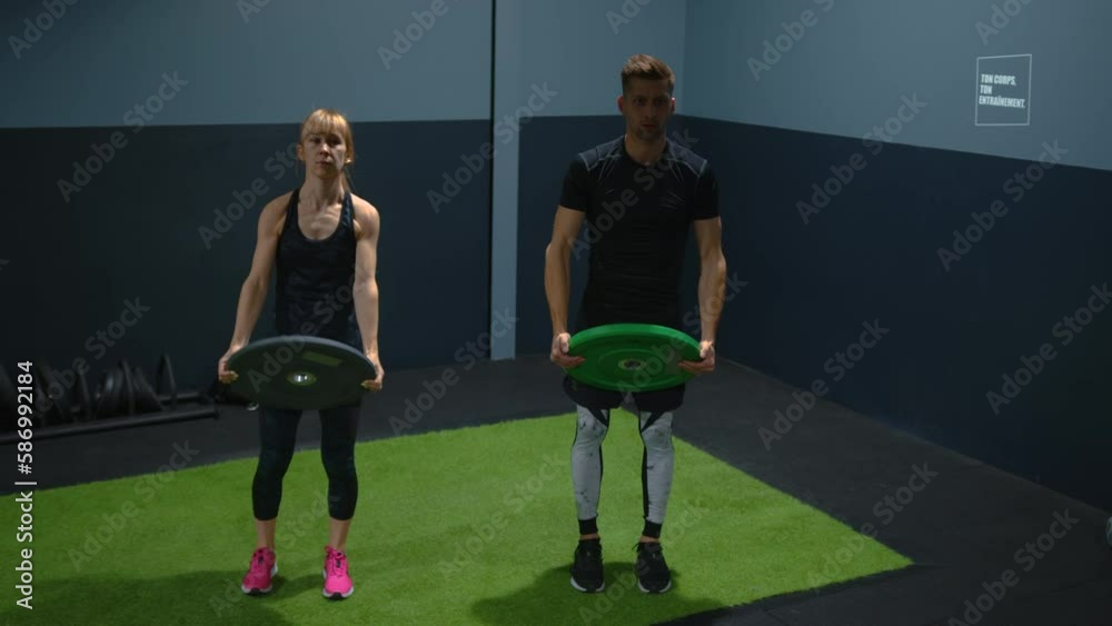 A young couple trains in the gym doing modern exercises to improve ...