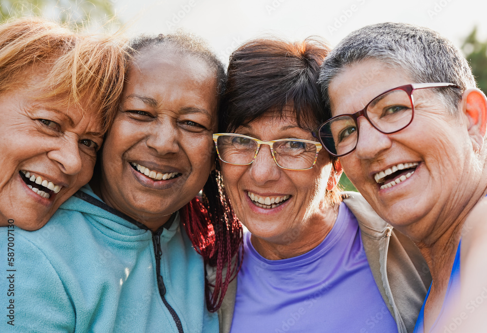 Fit multiracial senior women having fun after yoga class at city park ...