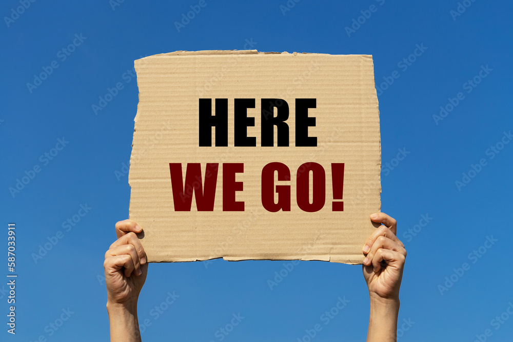 Here we go text on box paper held by 2 hands with isolated blue sky ...