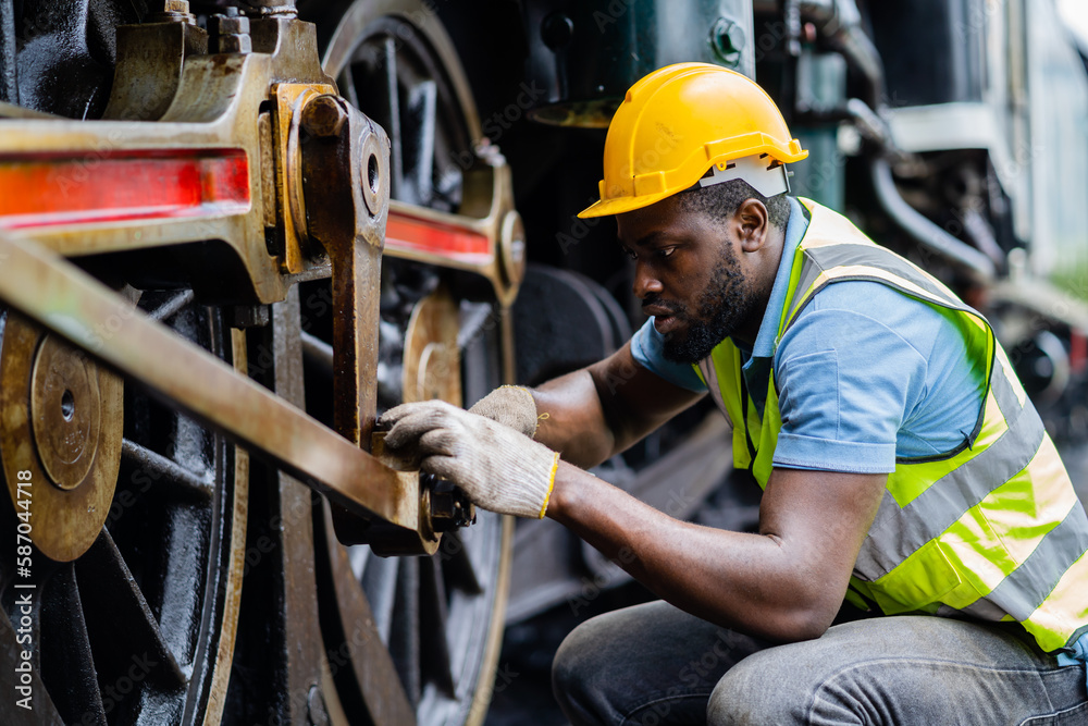 African engineer inspecting train wheels in train maintenance, safety ...