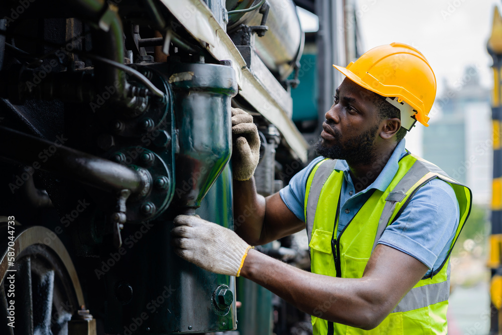 An African American railroad engineer inspects safety and maintains ...