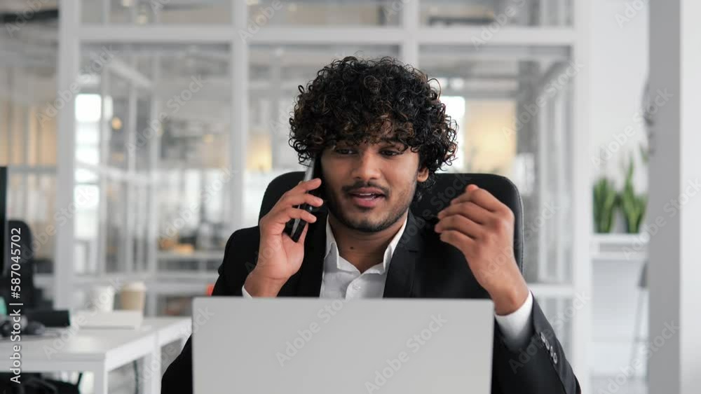 Busy handsome Indian man is seen multitasking in office male talks on ...