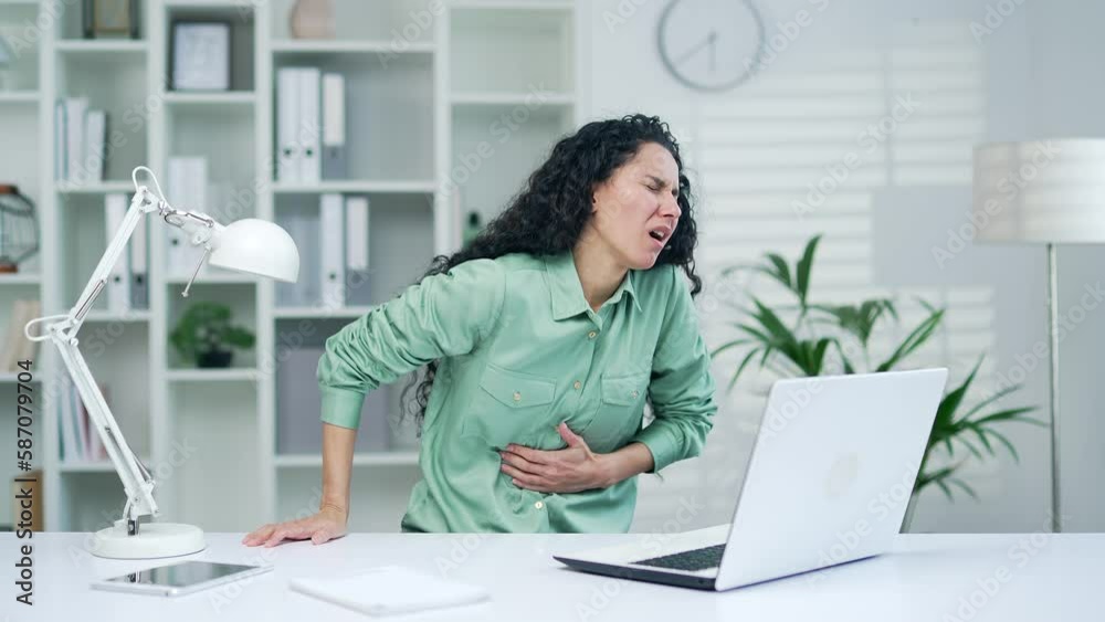 Sick young woman suffering from stomach ache during computer work ...