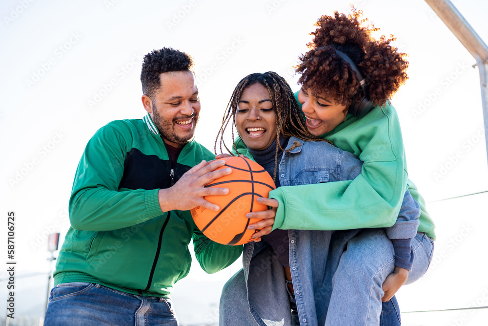 Foto de A group of diverse, multi-ethnic friends gather on a basketball ...