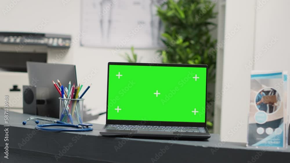 Laptop with blank green screen template at front desk, empty hospital ...