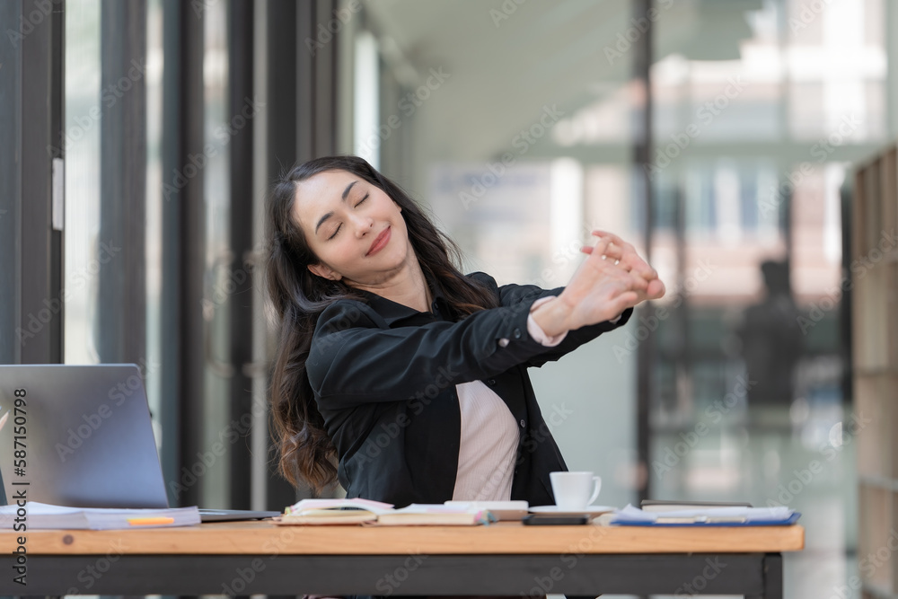 An Asian businesswoman feels tired from hard work, thus doing arm ...