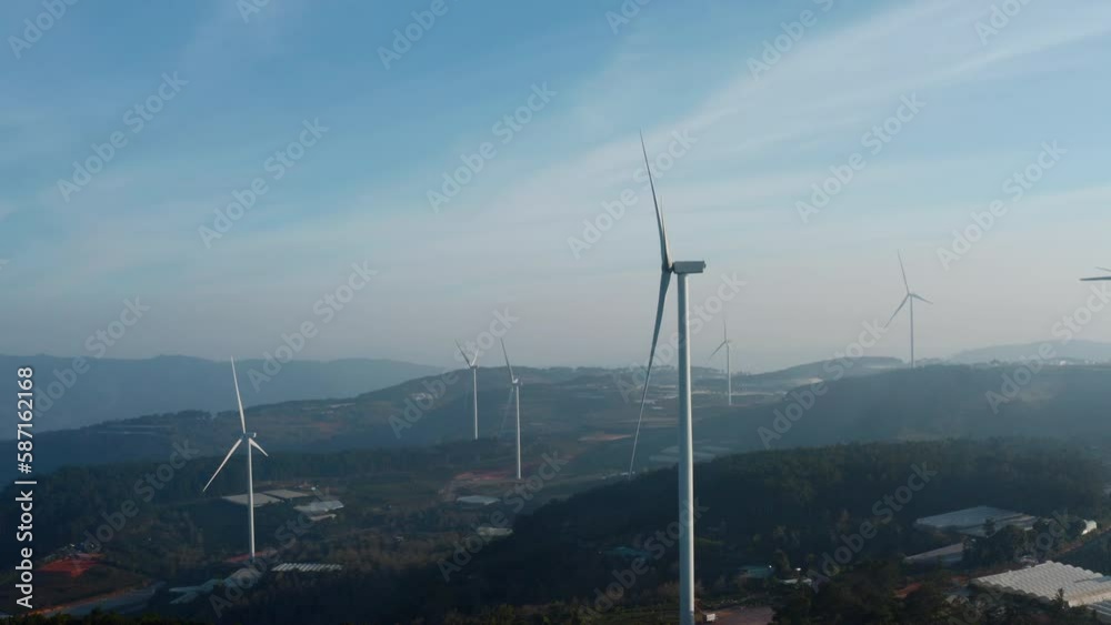 Rotating wind turbines generating green energy at the onshore wind farm ...
