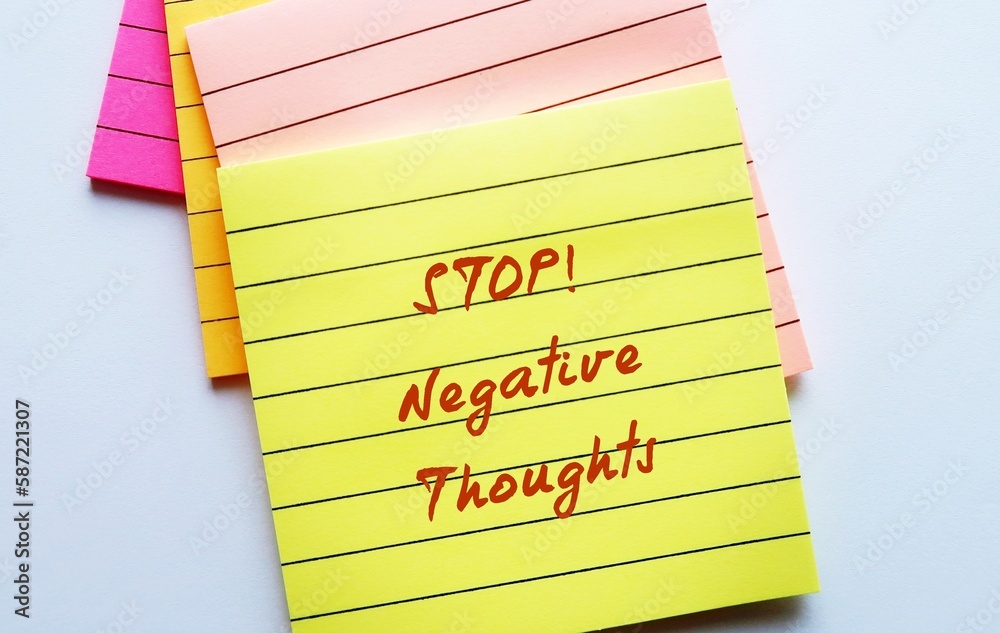 Foto de Pink note on orange background with pen written STOP NEGATIVE ...