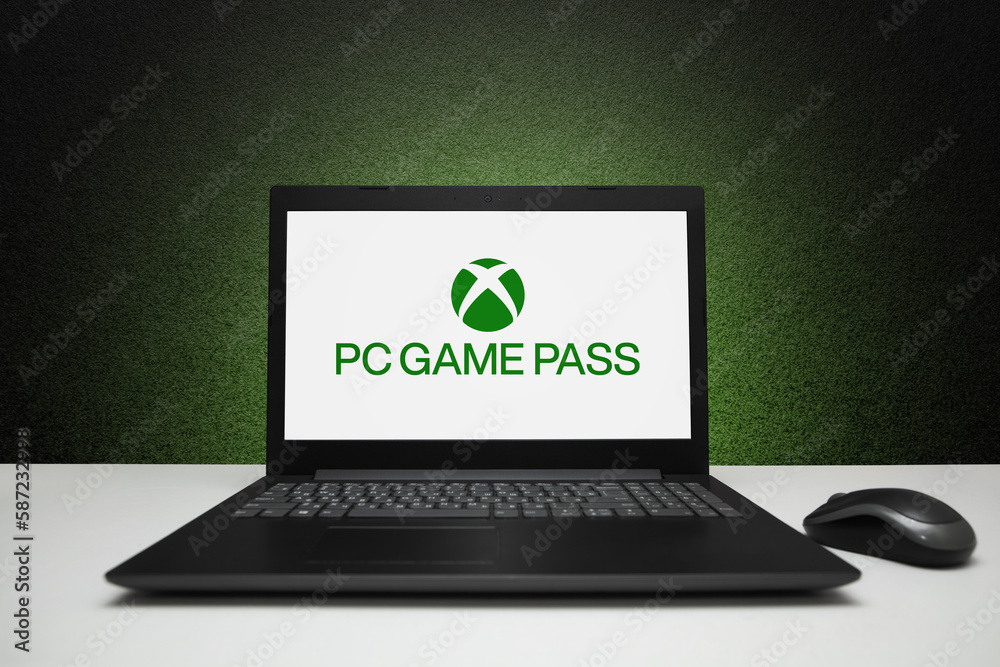 PC Game Pass logo on screen laptop computer with mouse on black ...