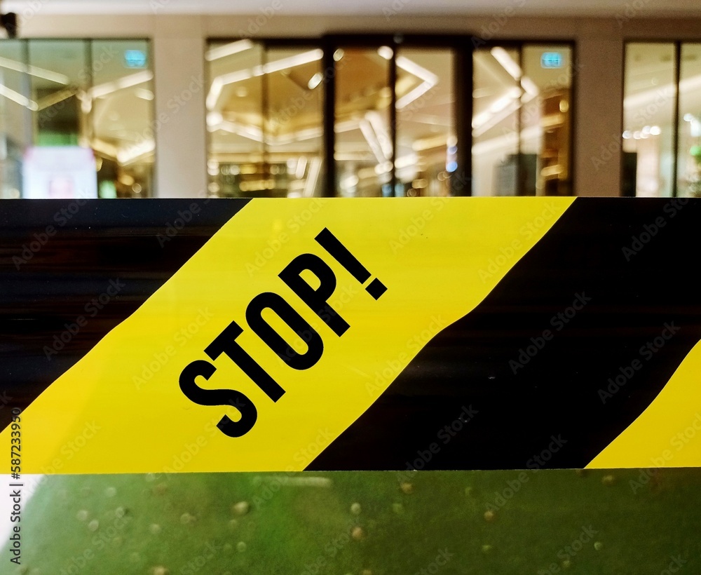 Brighly colored Barricade tape with text STOP! ,concept of to prevent ...