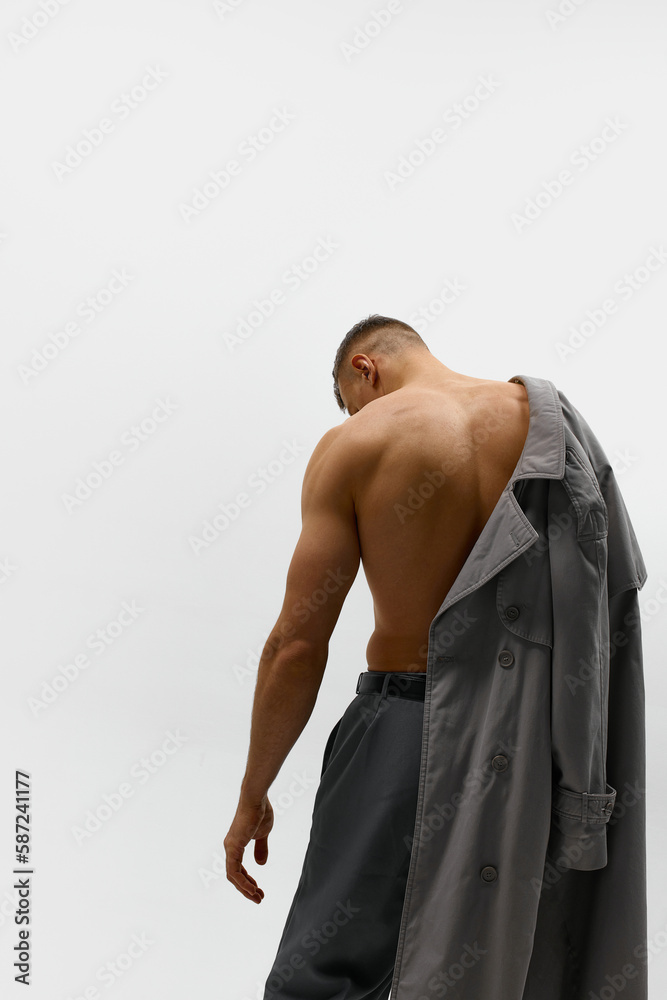 Back view photo with one atractive mascular man standing and holding ...