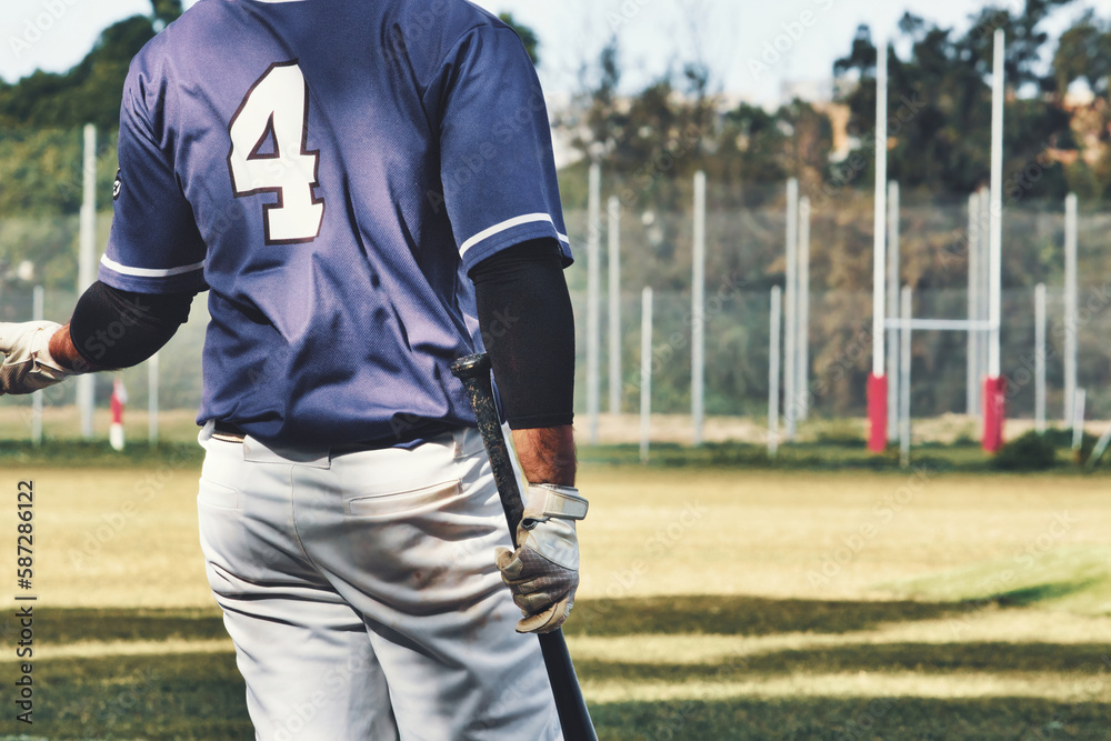 Rear view of a baseball player holding a bat wearing a team uniform on ...