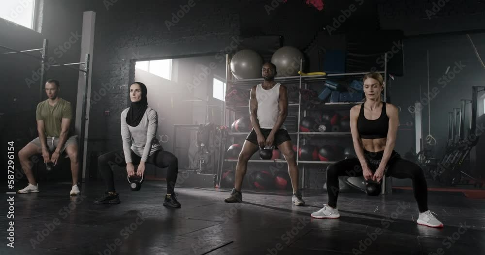 Mixed-raced group in sportswear training muscles and practicing ...