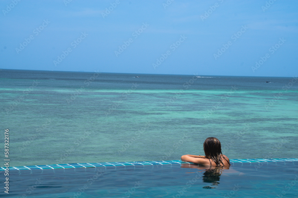 Woman in the infinity pool of a hotel while watching the sea Stock ...