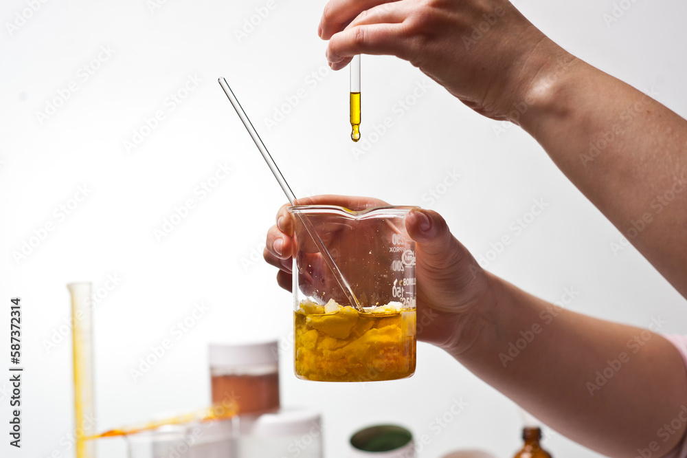 Dropping liquid from the dropper into a glass chemical vessel. Hands ...