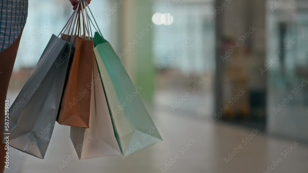 Shopping mall, Woman in a clothing store Relaxingly Holding paper bags ...