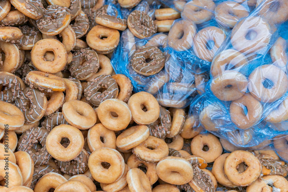 Many sweet and tasty round doughnuts, ring donuts covered with sugar ...