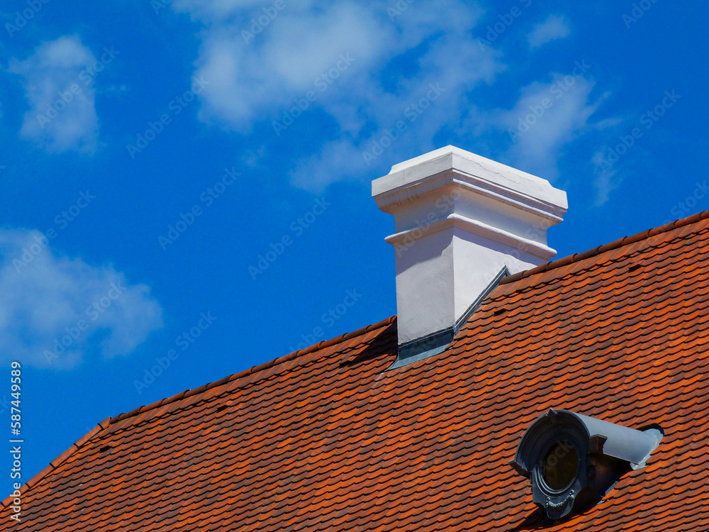 white stucco finished chimney. sloped roof with red brown clay roof ...