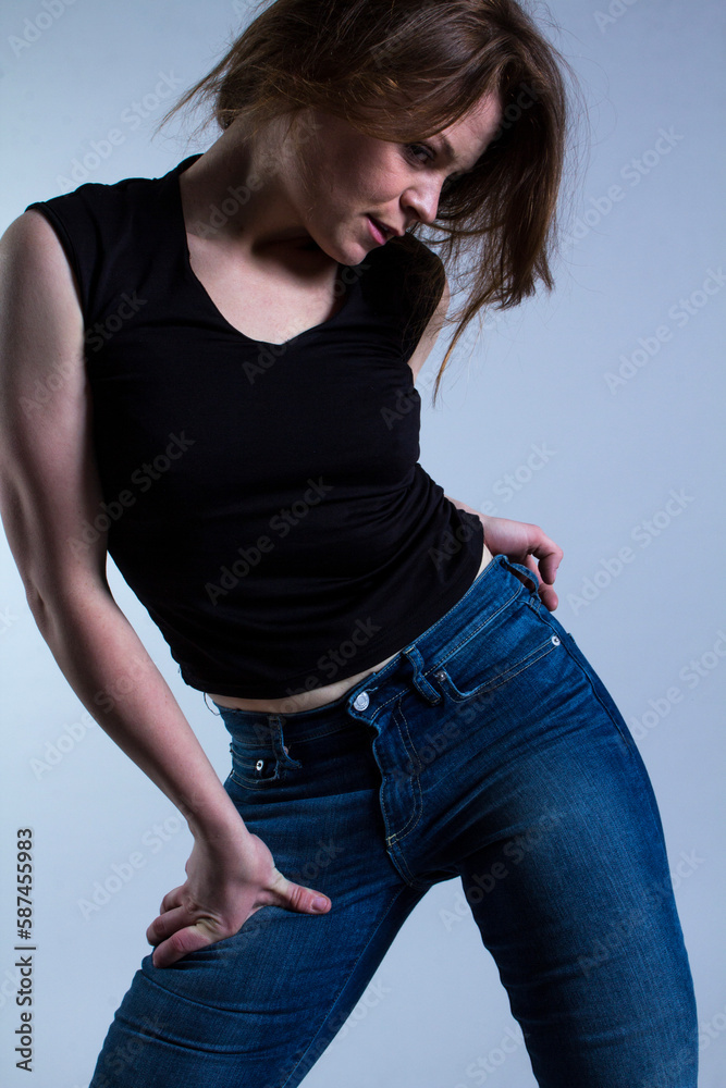 Pretty young woman dancing wearing tight jeans Stock Photo | Adobe Stock