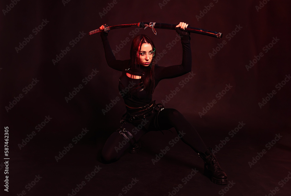 Female ninja draws a katana from its sheath in a fighting pose wearing ...