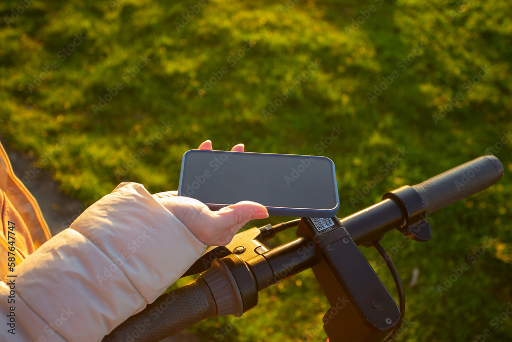 Foto de electric scooter rental, a woman scans a qr code on a scooter ...