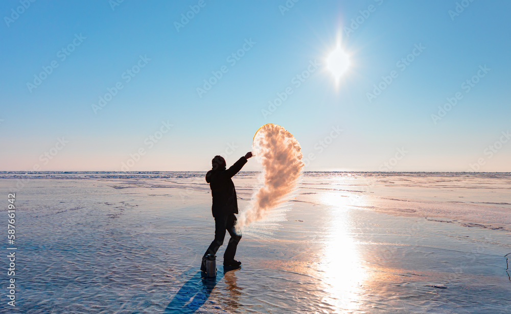 Man throwing boiling hot water freezing mid air. Water condensate ...