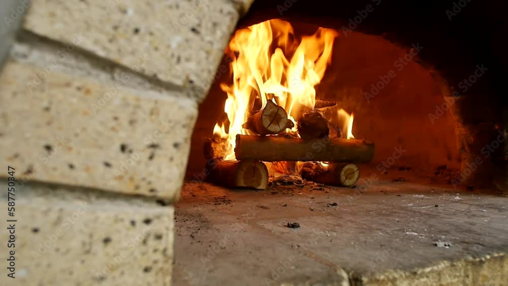 Dry firewood stacked in rectangular bright flames burns in a stone oven ...
