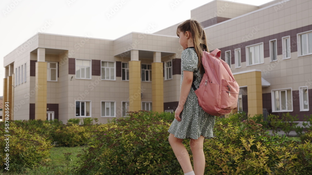 little child girl goes school with pink backpack. back view. school ...