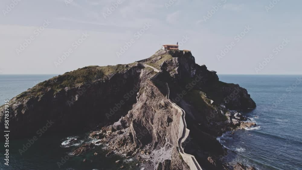 Aerial footage over Gaztelugatxe islet on the coast of Biscay at sunset ...