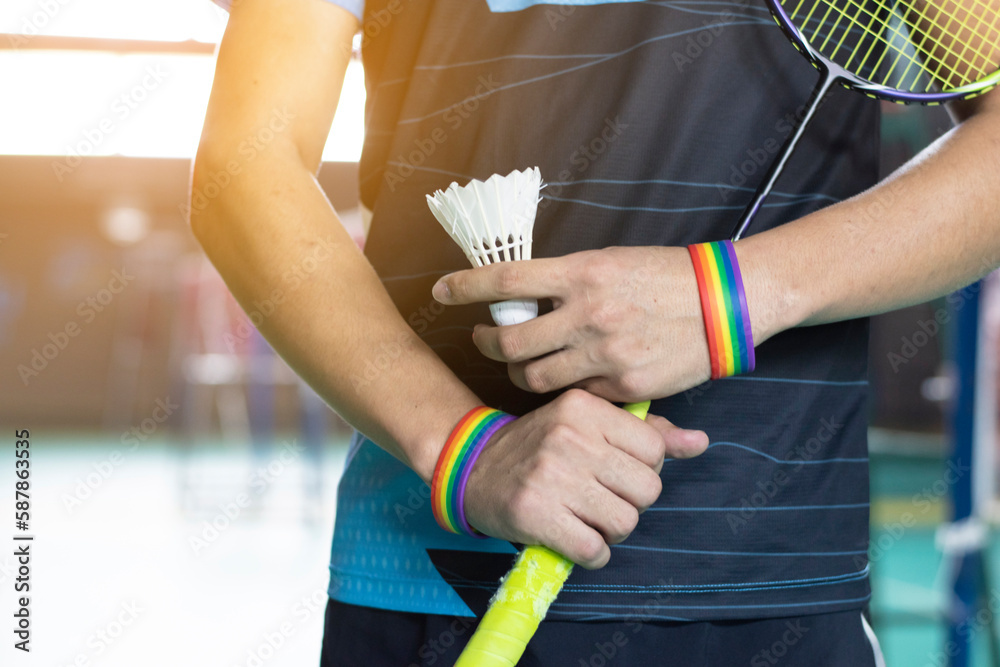 Badminton player wears rainbow wristbands, holding racket and white ...