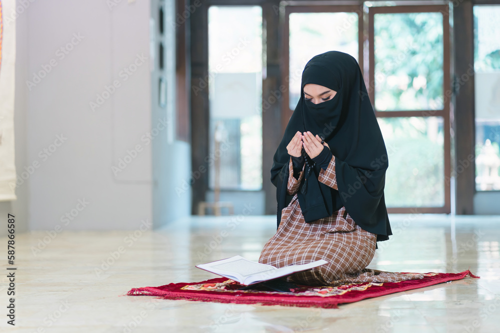 Muslim woman wearing a long Islamic hijab shows her praying and making ...