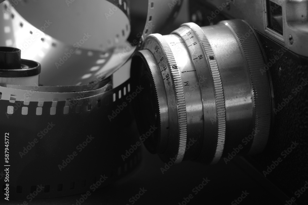 scratched dusty photo film stripe and retro camera lens in the ...