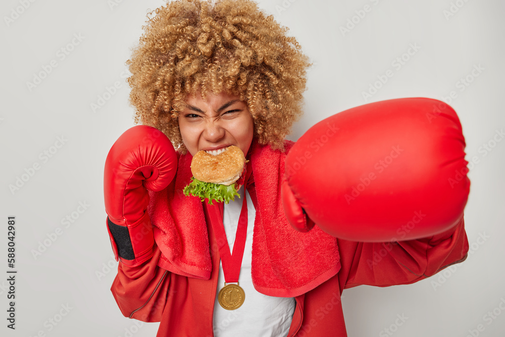 Professional box concept. Serious curly haired female boxer stands in ...