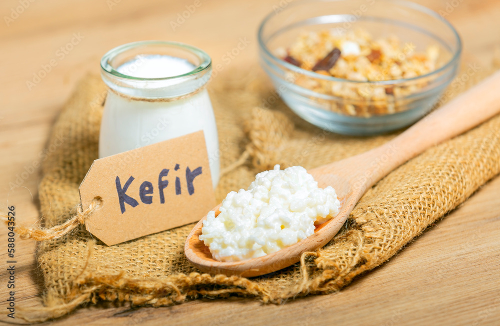 Kefir grains in wooden spoon in front of cups of Kefir Yogurt Parfaits ...