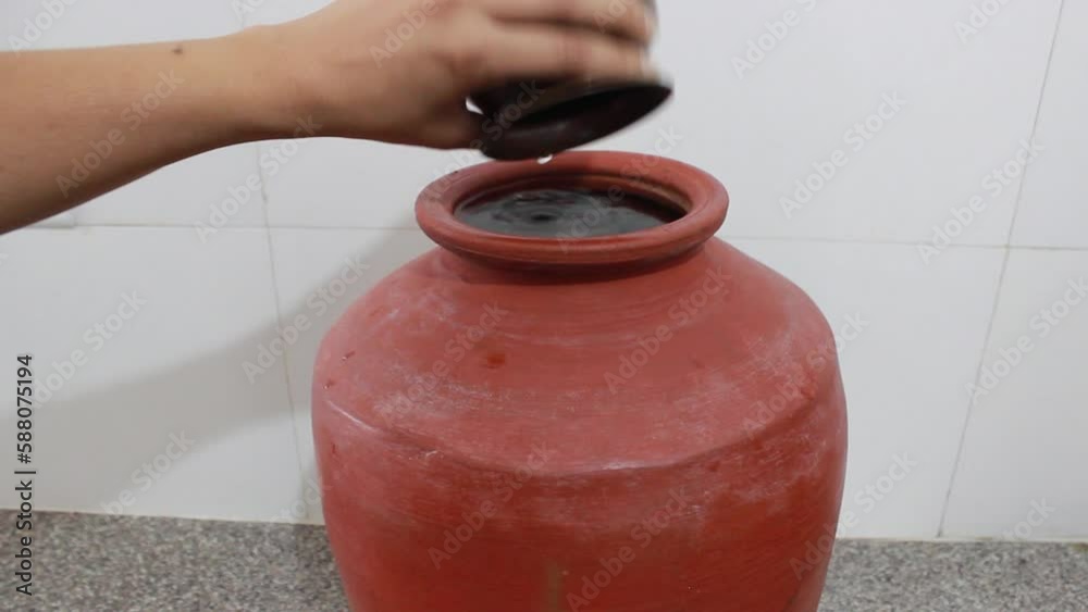filling the matka, water pot for having the drinking water in summer in ...
