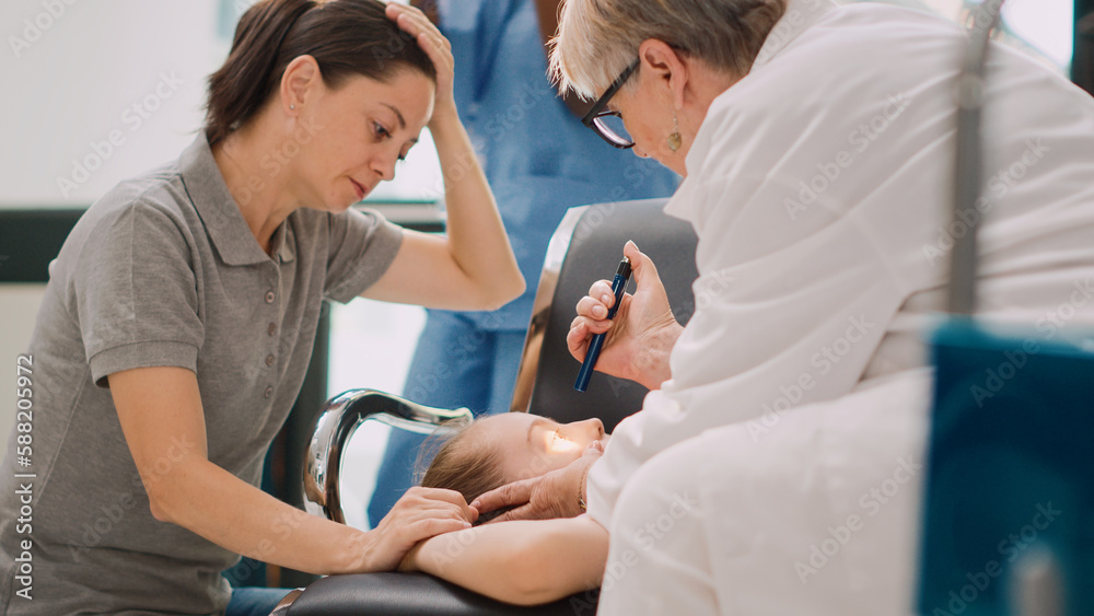 Diverse medical team consulting little girl being unconscious, using ...