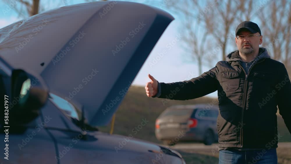 Stockvideo Confused man standing near broken car with open hood and ...