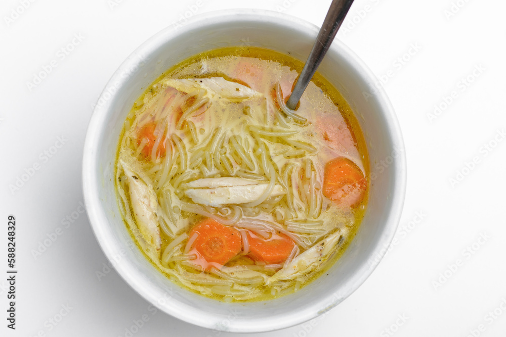 Polski tradycyjny Rosół z kury z makaronem i marchewką w białej misce z ...