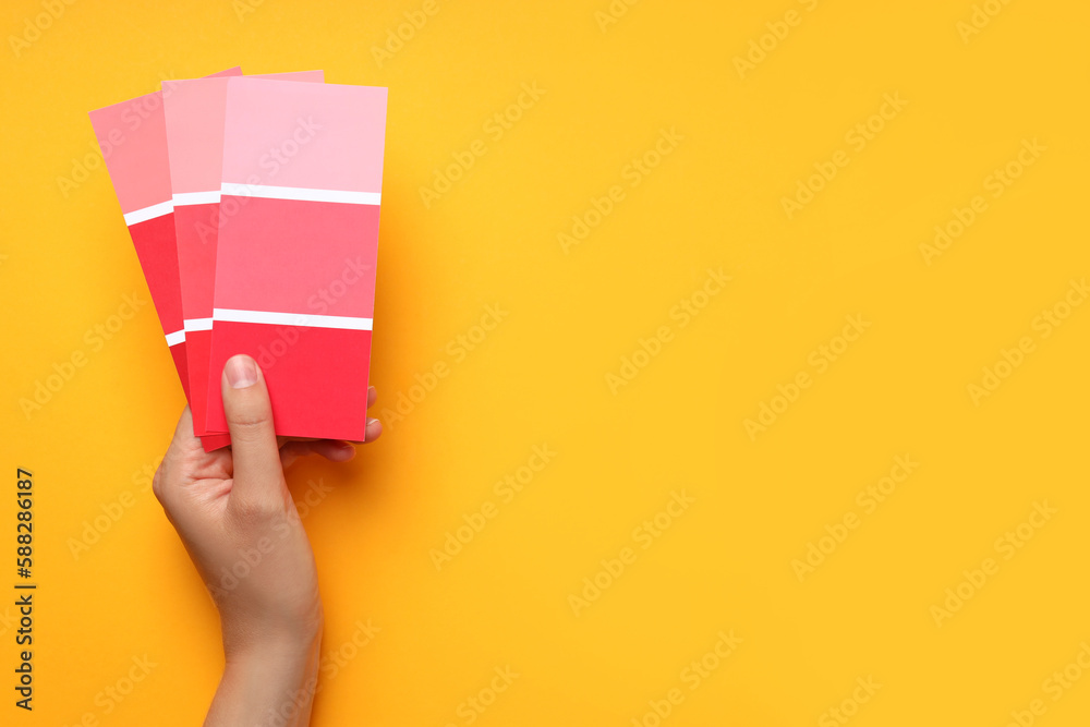 Female hand holding color palettes on yellow background Stock Photo ...
