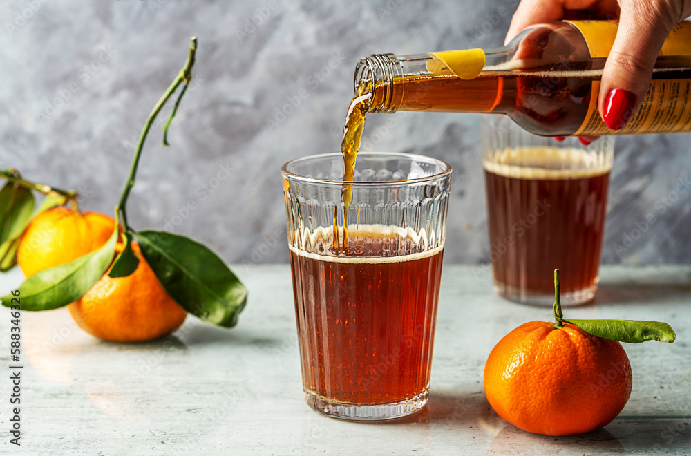 Chinotto refreshing citrus drink in a glass, woman's hand holding ...