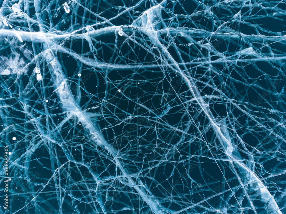 The natural texture of winter ice with white bubbles and cracks on a ...