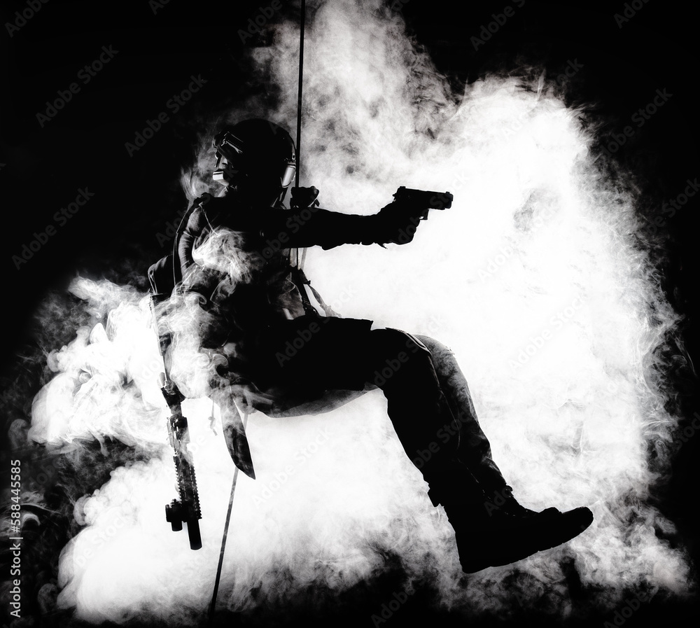 Silhouette of police officer in tactical gear descending from a height ...