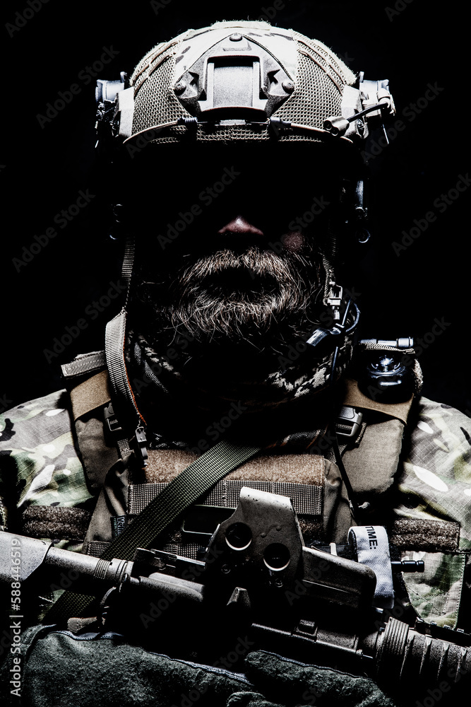 Close up, low key half length portrait of bearded commando fighter ...