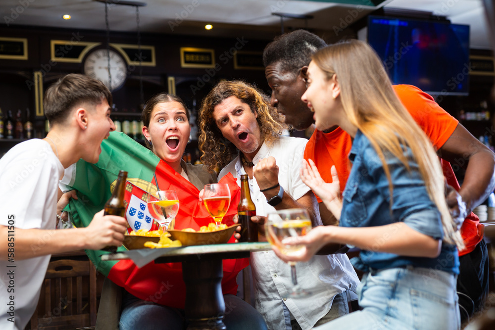 Foto de Excited young adult football fans having fun in sports bar ...